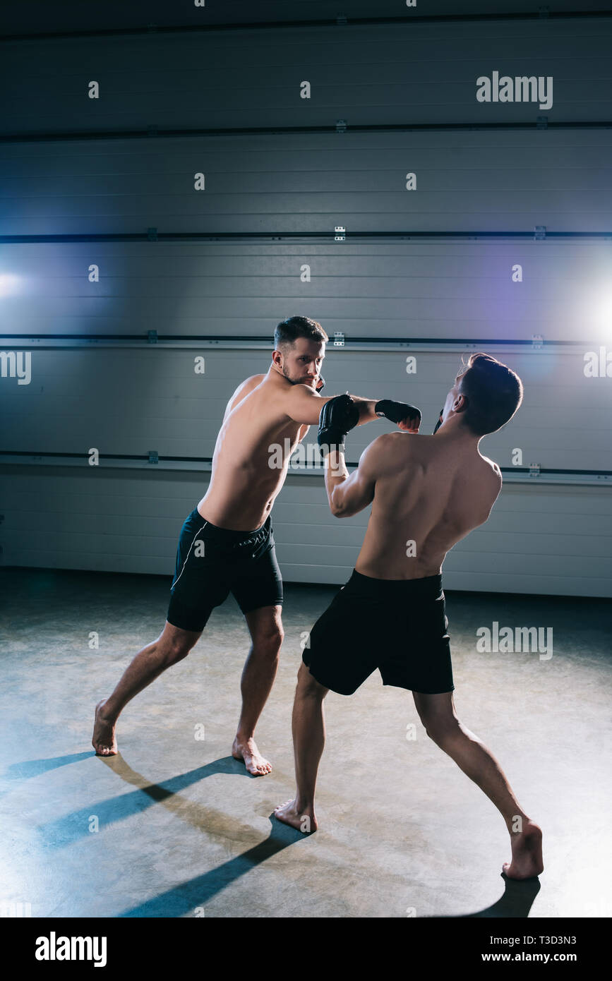strong barefoot mma sportsmen fighting while man punching another Stock ...