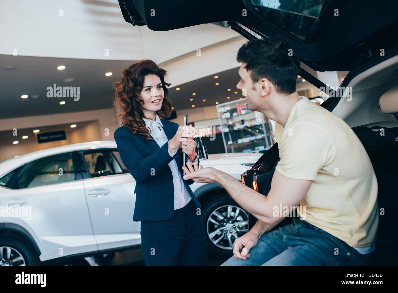 selective focus of happy customer taking car keys from attractive car ...
