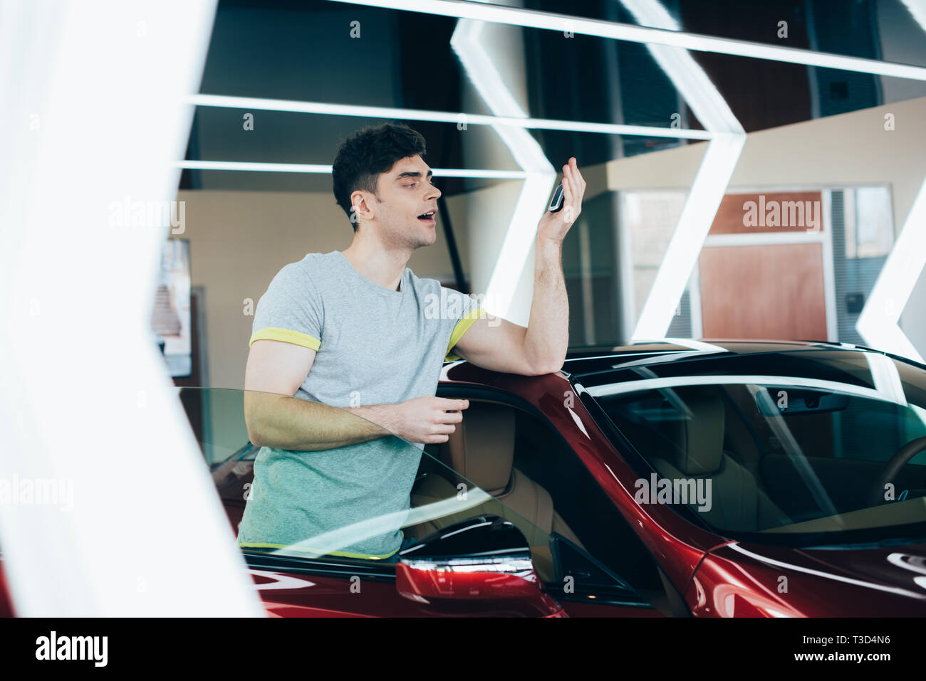 selective focus of happy man holding car keys while standing near new ...