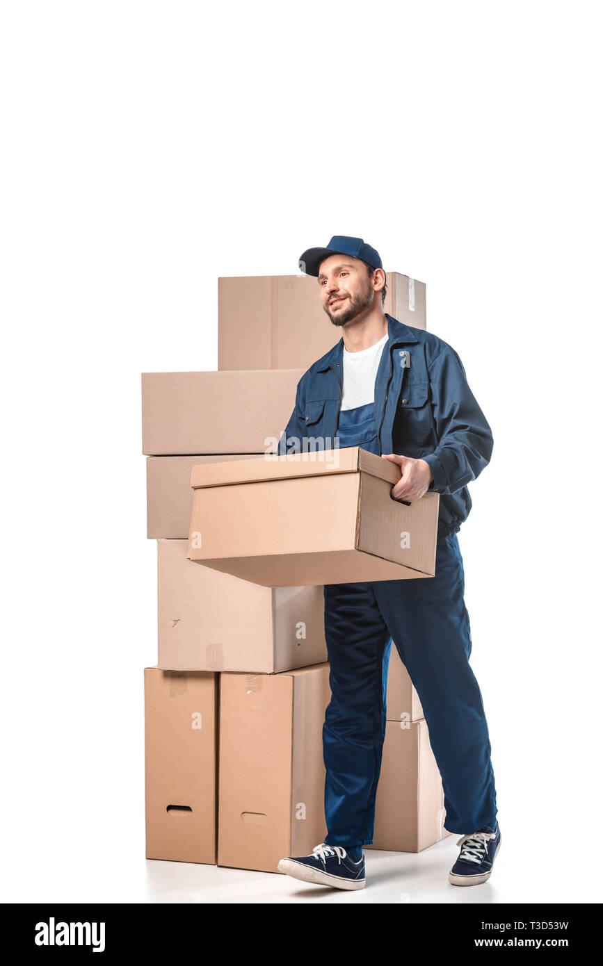 handsome mover in uniform carrying cardboard box isolated on white ...