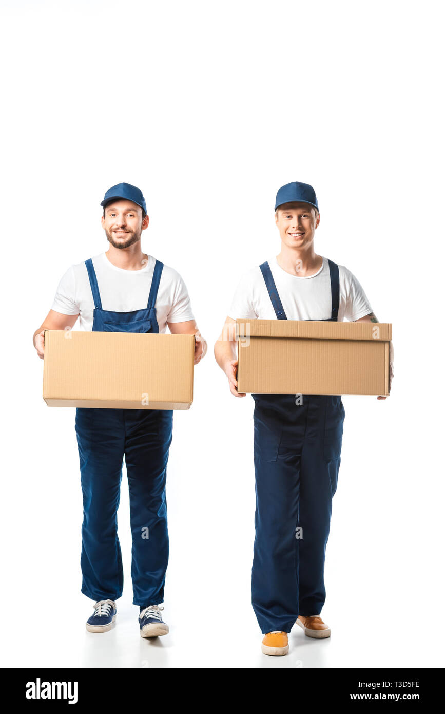 two handsome movers looking at camera while transporting cardboard ...