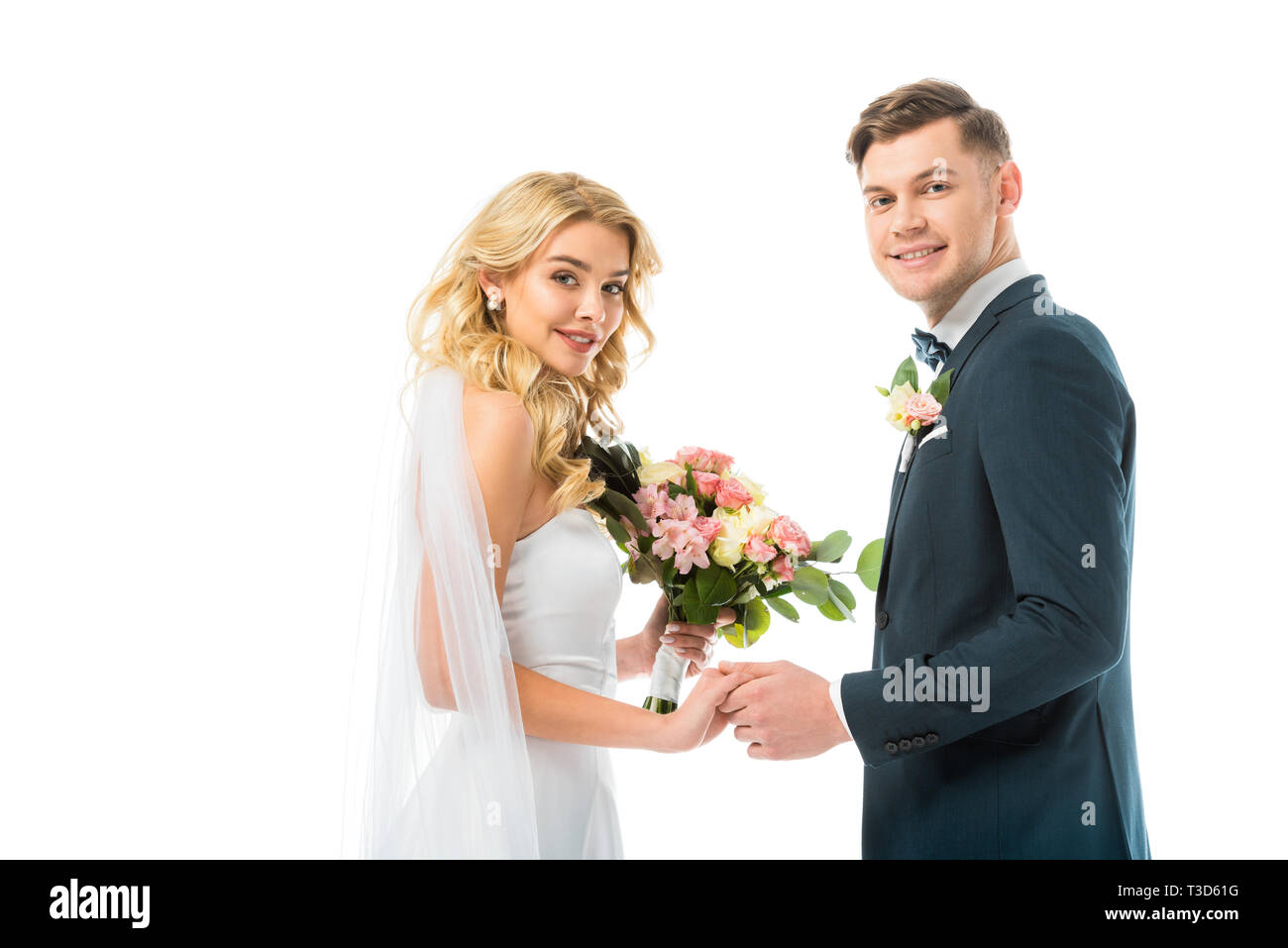 beautiful bride and handsome groom holding hands and looking at camera ...
