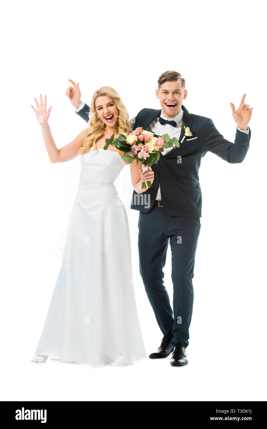 cheerful bride and groom waving hands while looking at camera isolated ...
