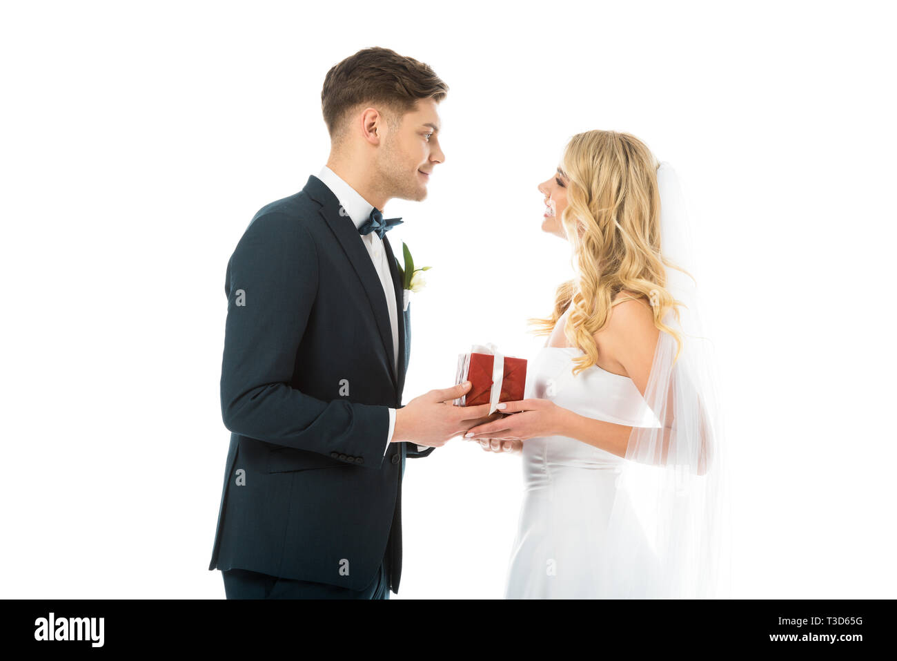 happy groom presenting gift box to smiling bride isolated on white ...