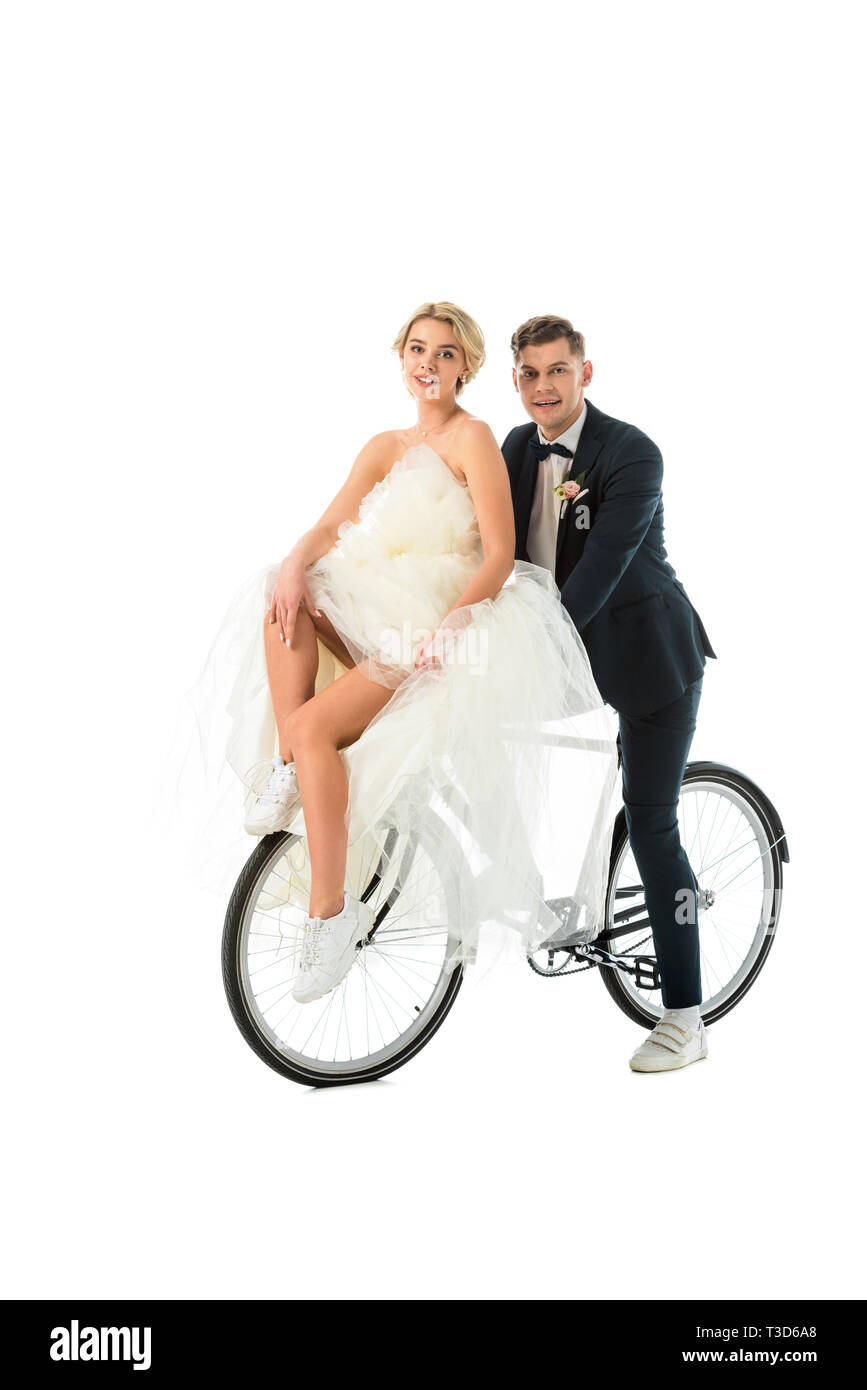 beautiful bride in wedding dress and handsome groom sitting on bicycle ...