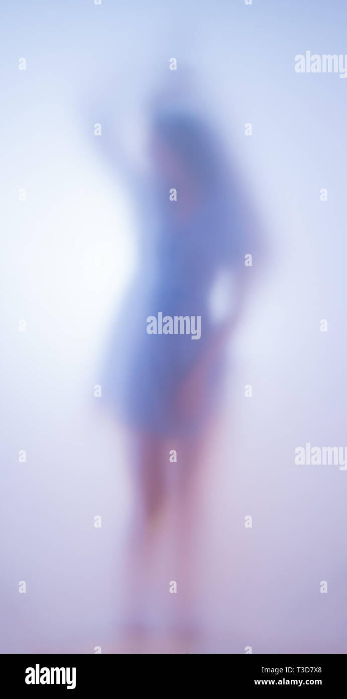 Blurred photo girl wearing dress dancing behind glass Stock Photo - Alamy