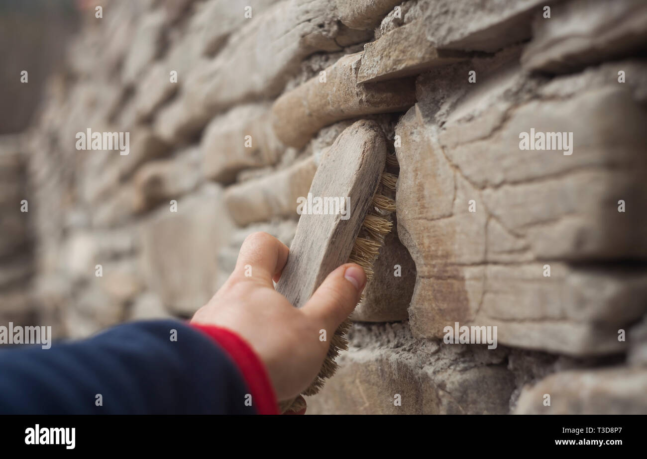 hand with brush on stone wall Stock Photo - Alamy