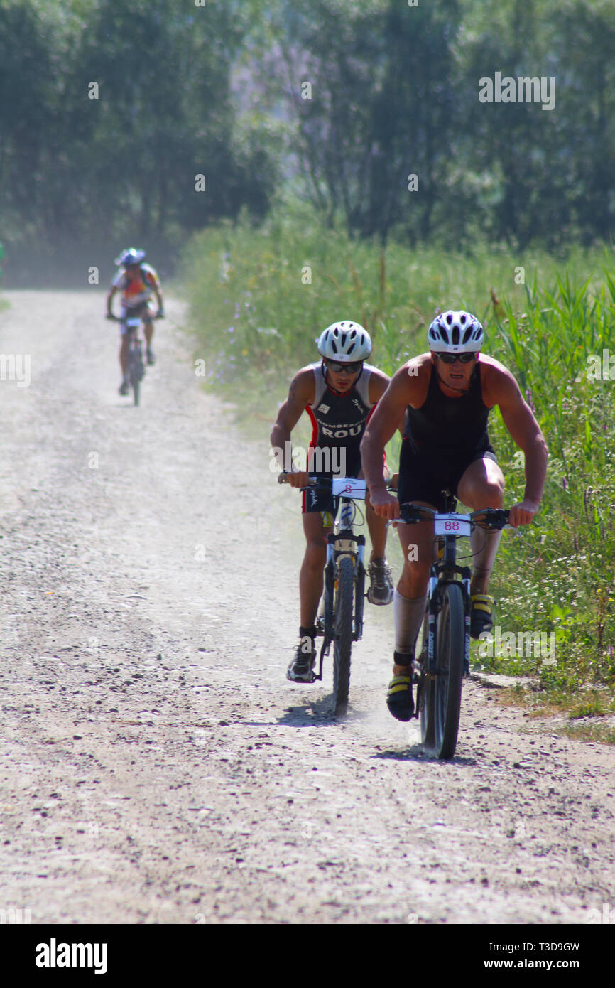 Group of triathlonists approaching on mountain bikes during competition ...