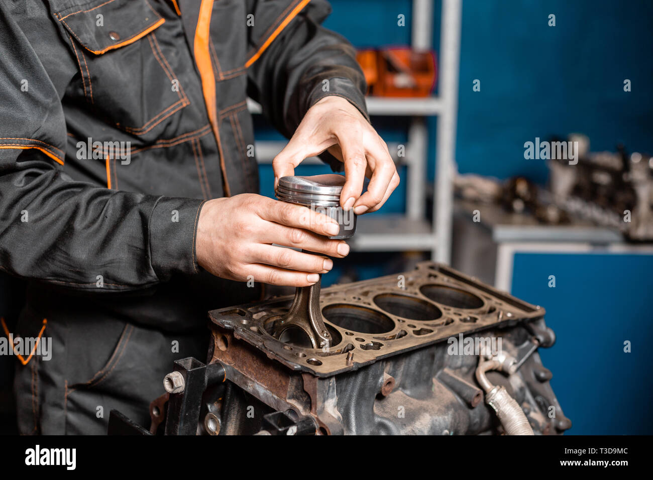 Car mechanic holding a new piston for the engine, overhaul.. Engine on ...