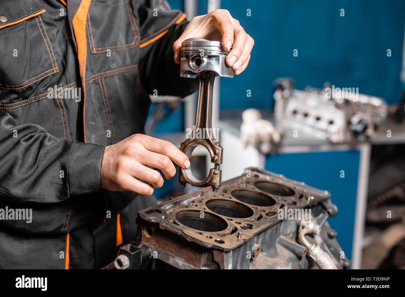 Car mechanic holding a new piston for the engine, overhaul.. Engine on ...