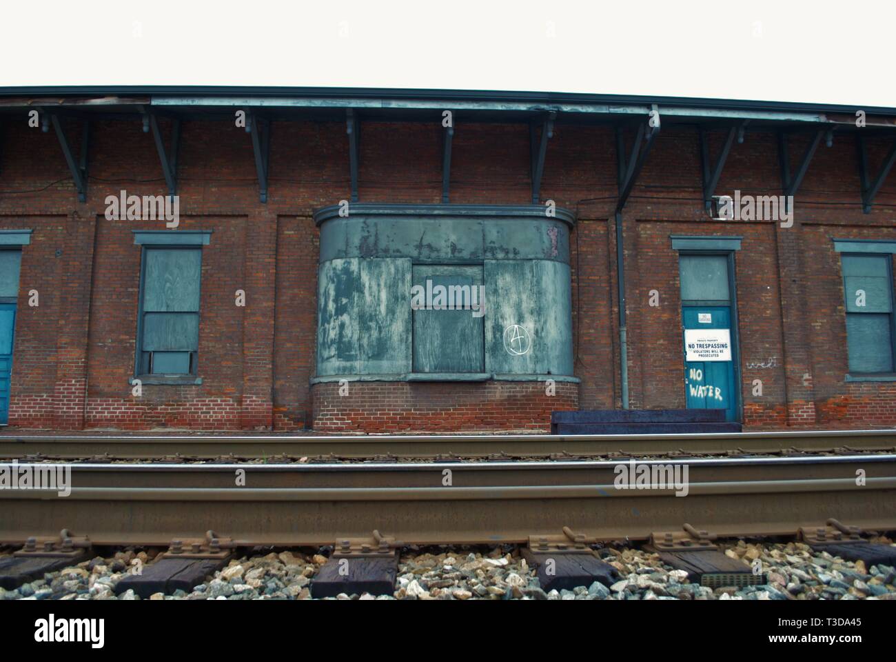 abandoned brick train depot with tracks and graffiti Stock Photo - Alamy