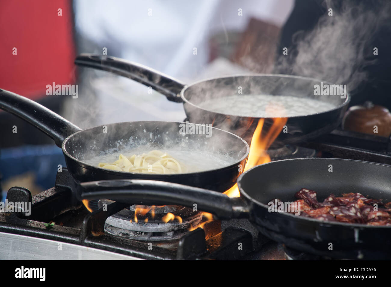Frying pan on fire, chef Frying vegetables on fire throwing them in a ... Frying pan on fire, chef Frying vegetables on fire throwing them in a ...