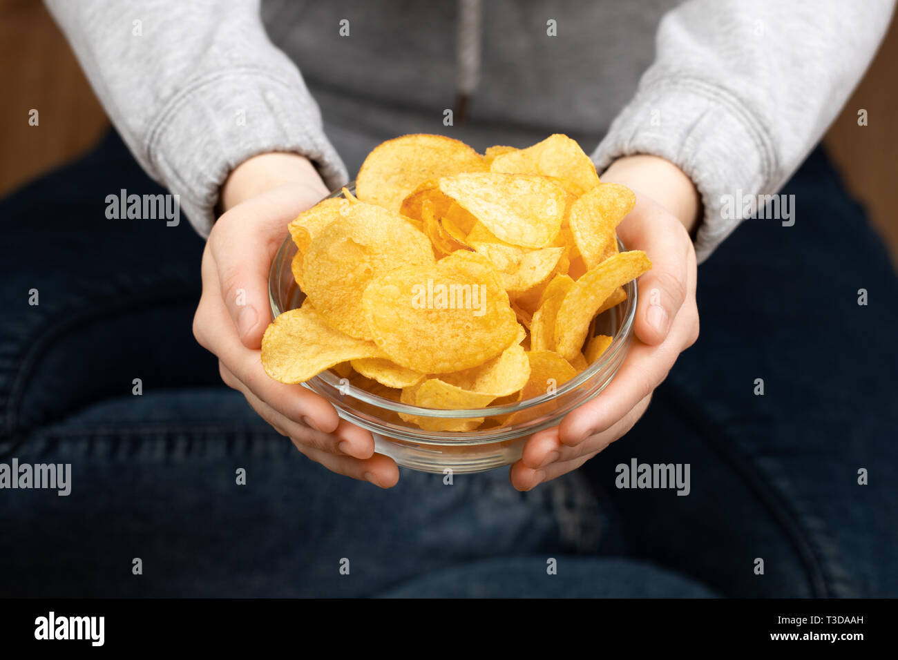 Female hand giving crispy potato chips bowl Stock Photo - Alamy