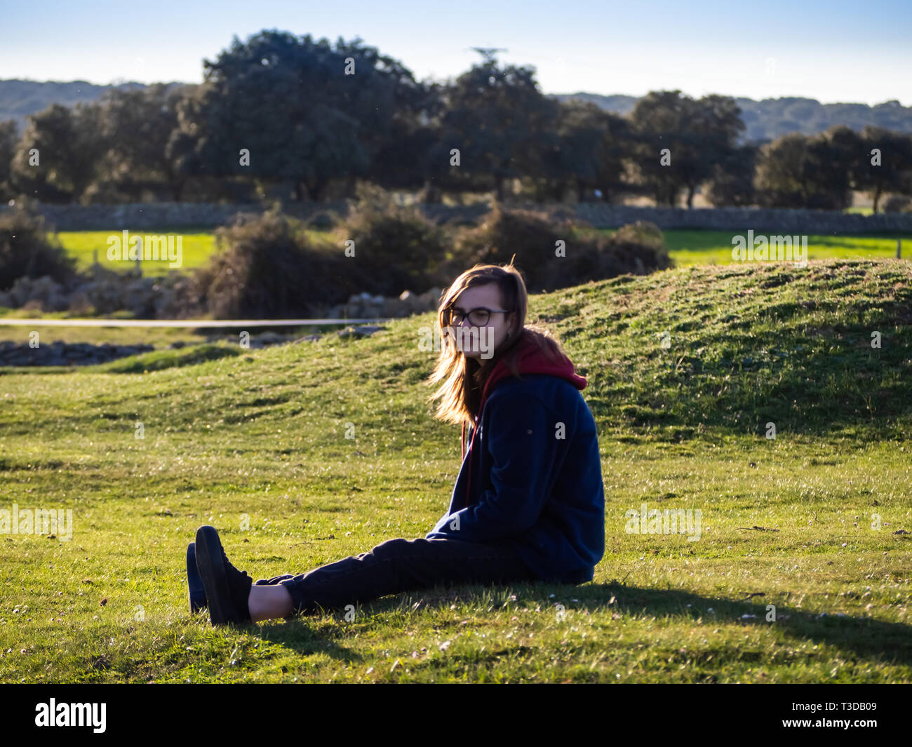 A teenage woman in the field in spring taking a sunbath Stock Photo - Alamy