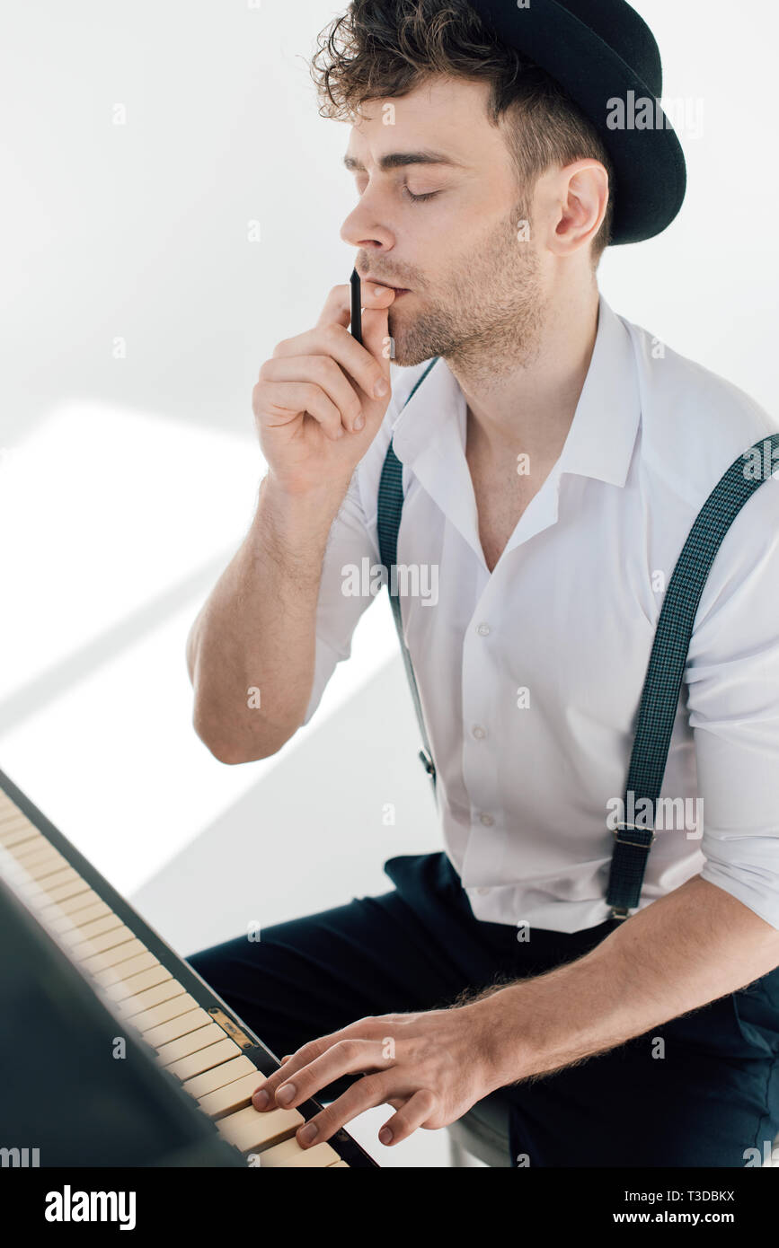 thoughtful man composing music while sitting at piano Stock Photo - Alamy