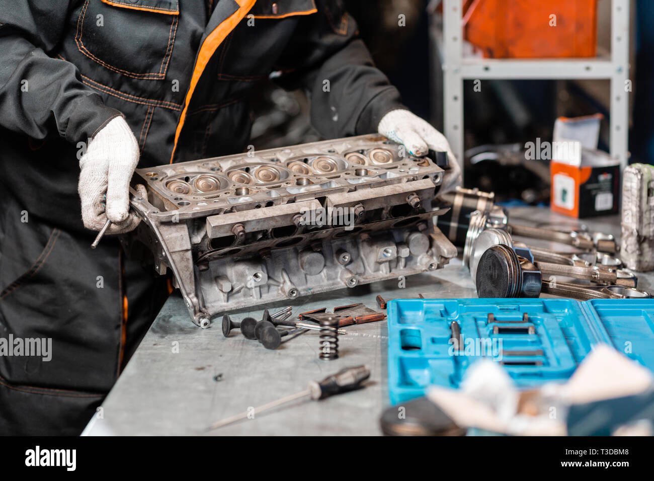 Mechanic disassembling the engine, overhaul.. Engine on a repair stand ...