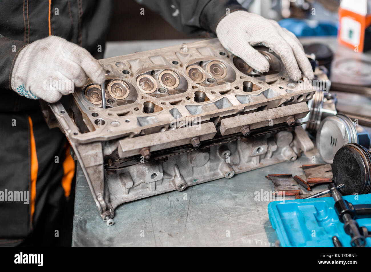 the mechanic installs a new valve. Disassemble engine block vehicle ...
