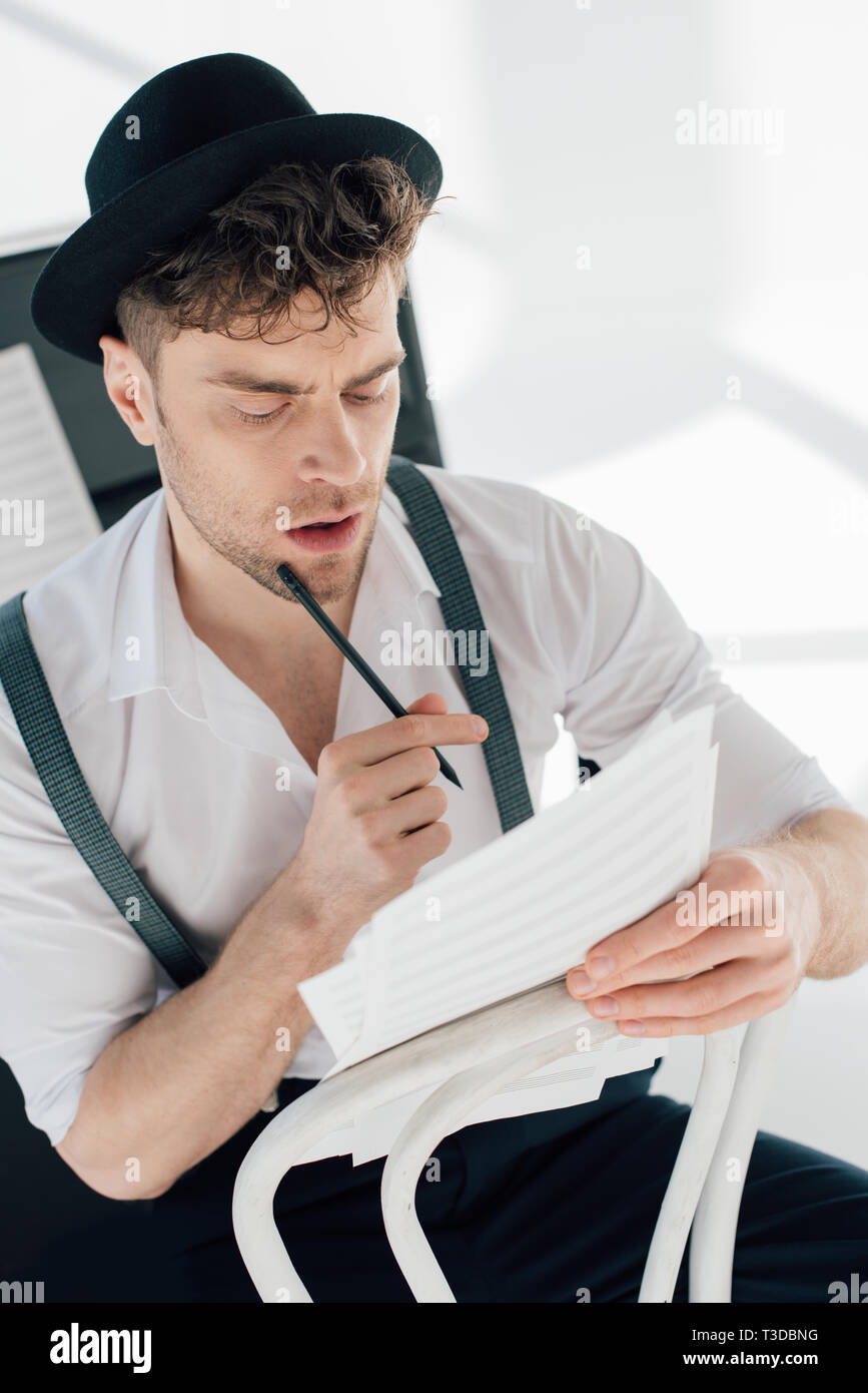 thoughtful composer looking at music book sheets Stock Photo - Alamy