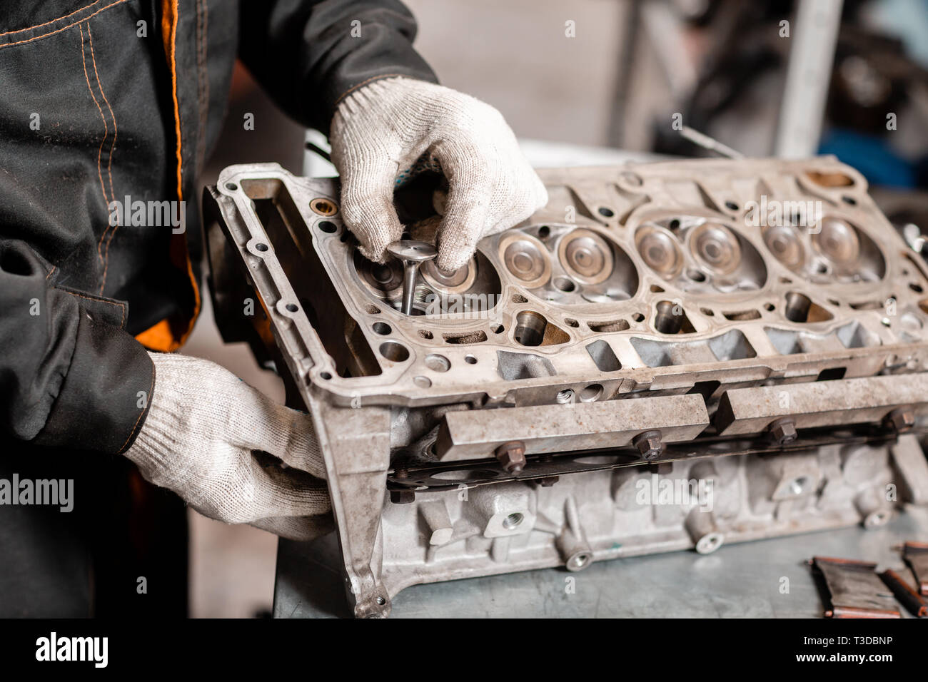 the mechanic installs a new valve. Disassemble engine block vehicle ...