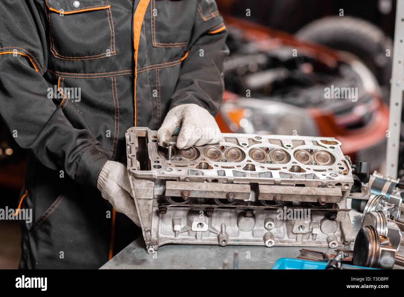the mechanic installs a new valve. Disassemble engine block vehicle ...