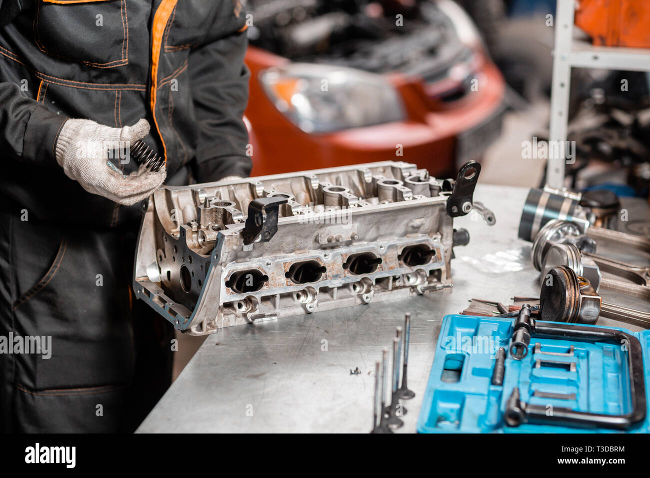 Mechanic disassembling the engine, overhaul.. Engine on a repair stand ...