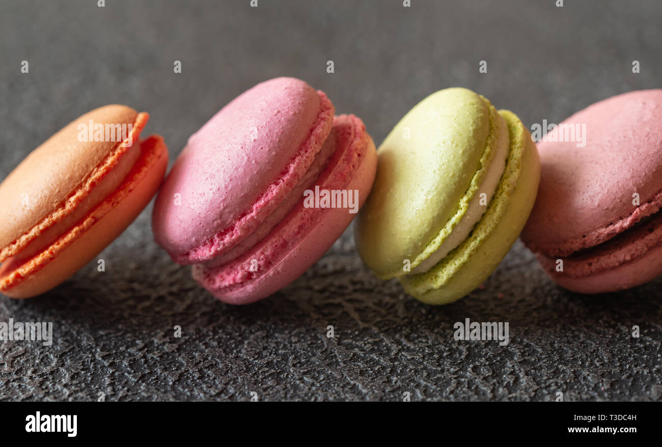 Colorful macarons on the dark background Stock Photo - Alamy