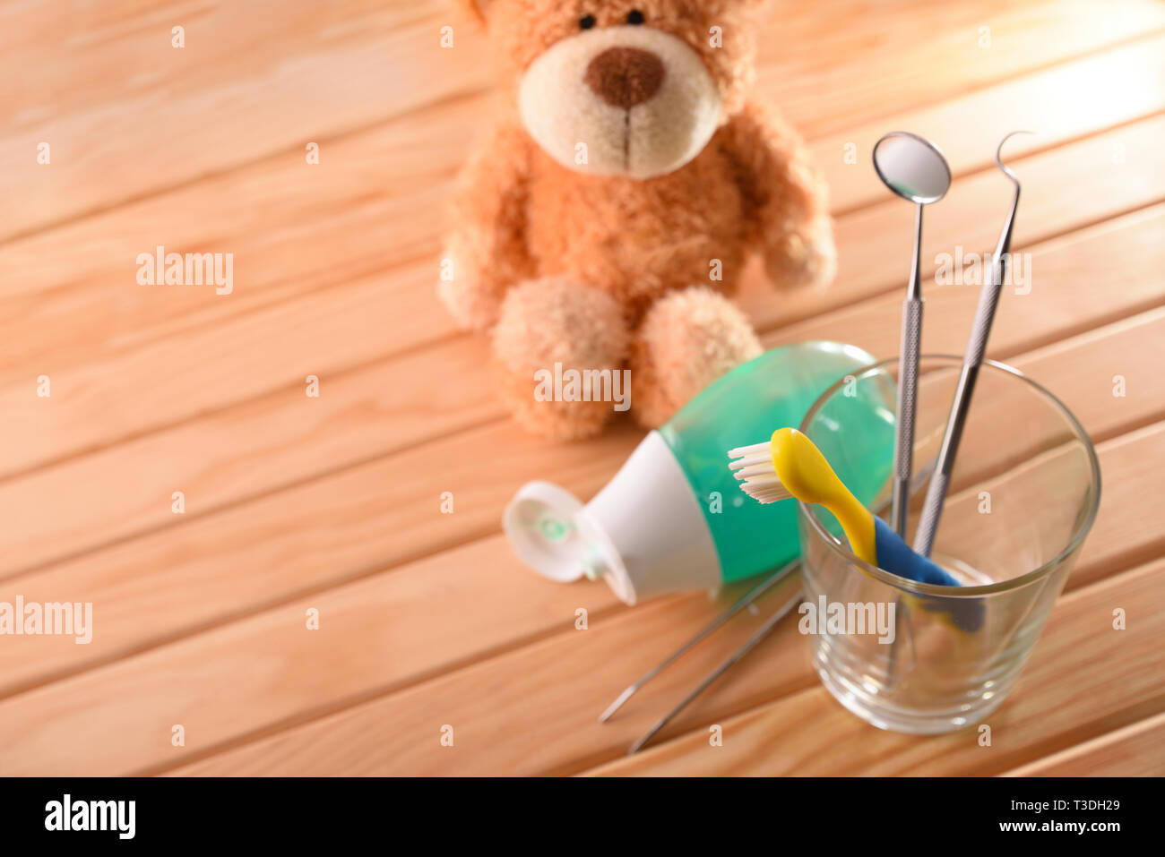 Dentist concept for children with tools in glass cup and teddy on ...