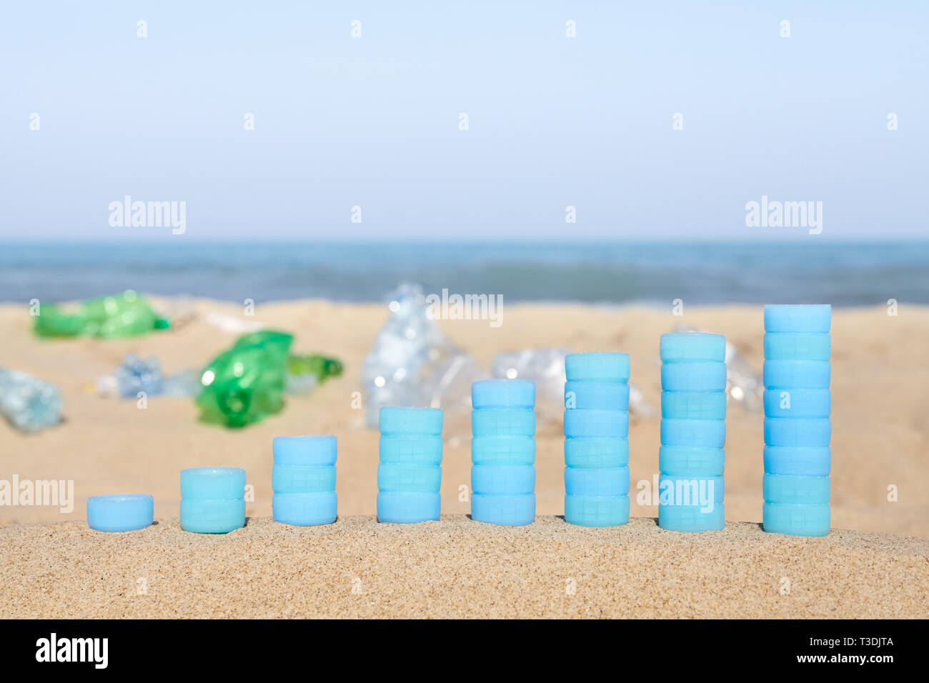Chart made of plastic bottles caps on sand showing the increase in ...