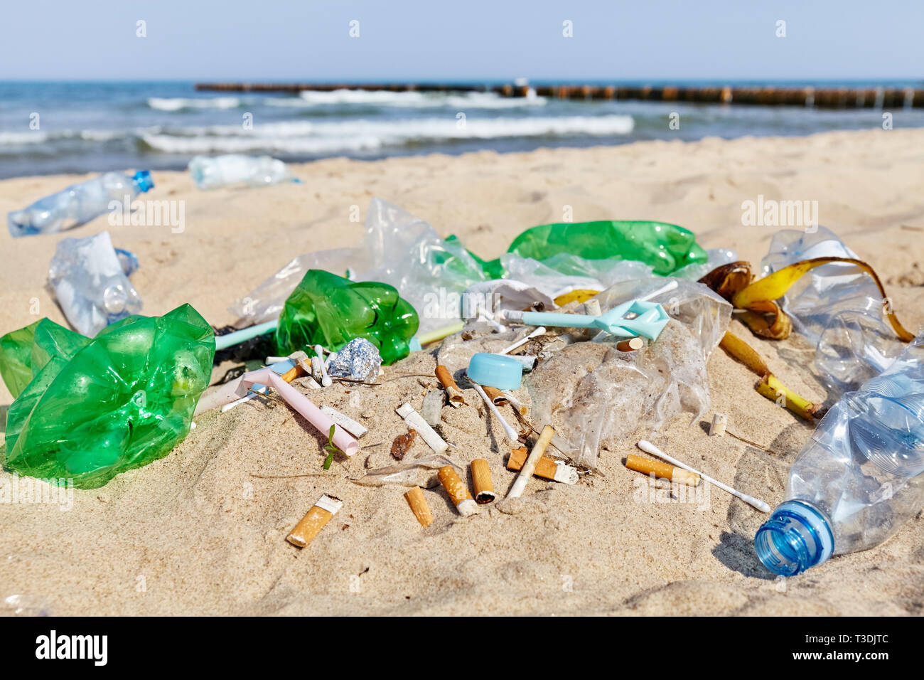 Plastic bottle cap among other single use products and cigarette butts ...