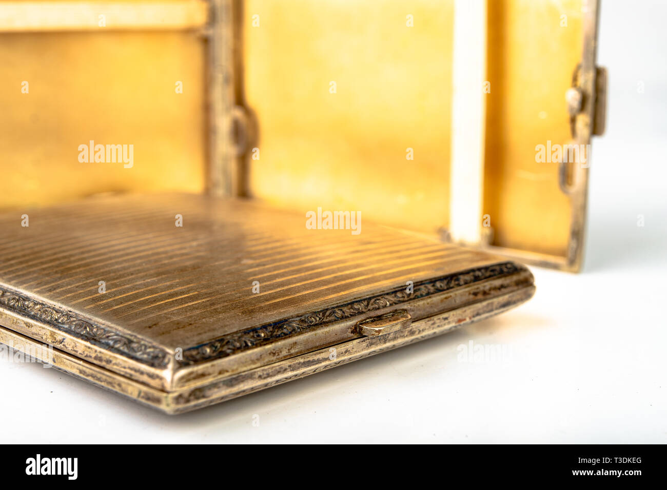 Metal old tobacco-pipe on a white table. Old-style cigarettes pack ...