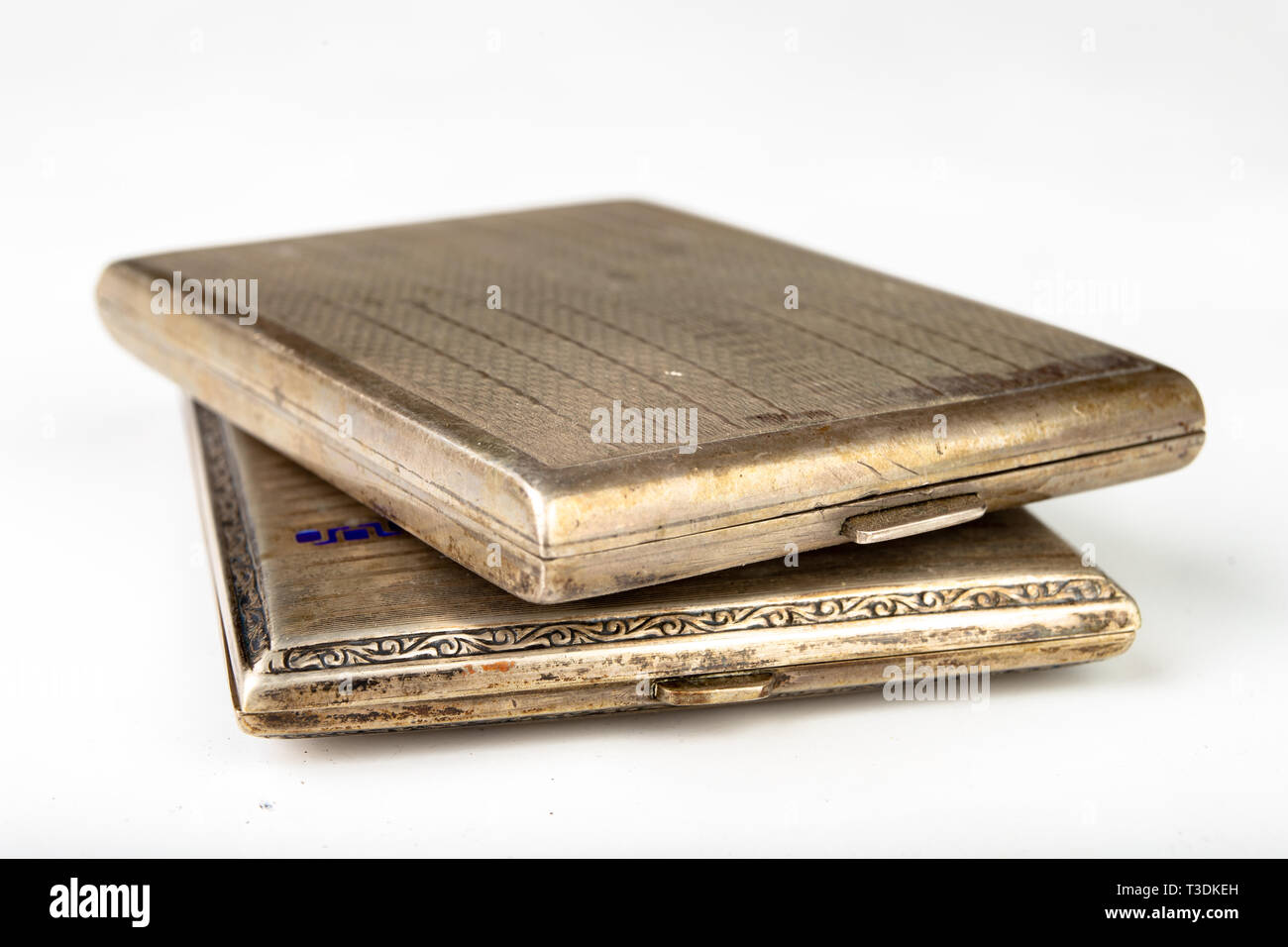 Metal old tobacco-pipe on a white table. Old-style cigarettes pack ...