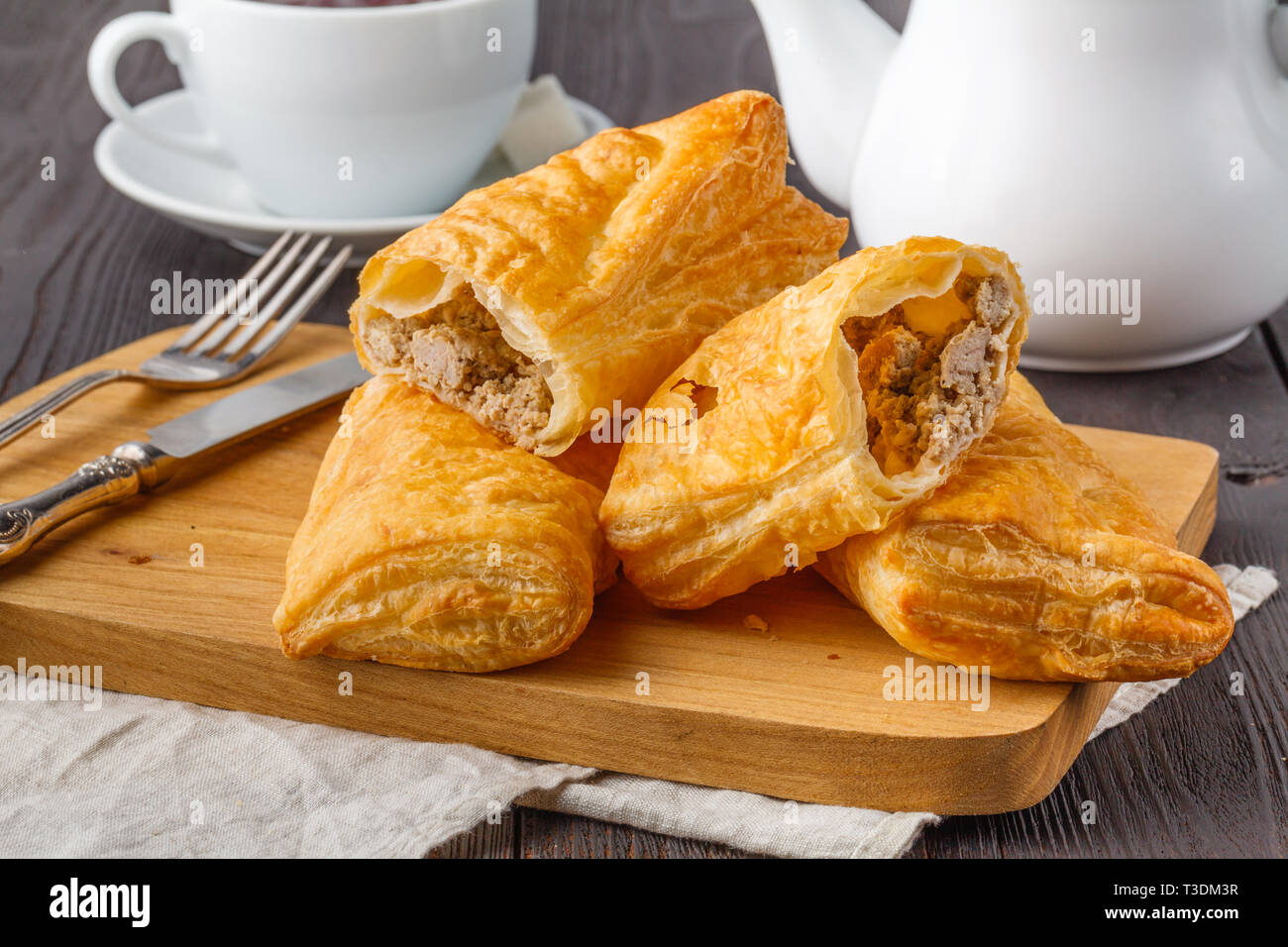 Puff pastry triangles filled with feta cheese and spinach on wooden ...