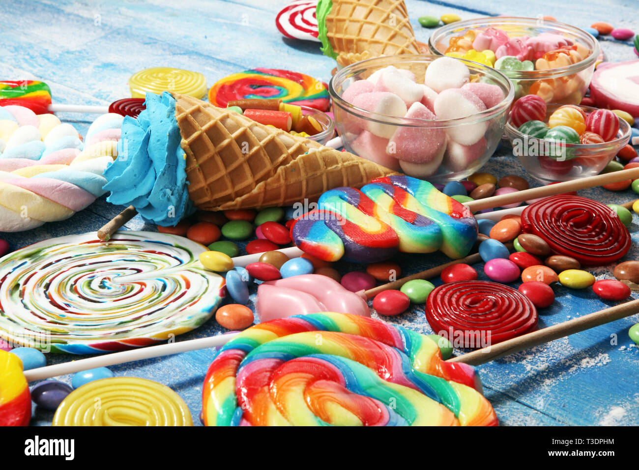 candies with jelly and sugar. colorful array of different childs sweets and treats on blue ...
