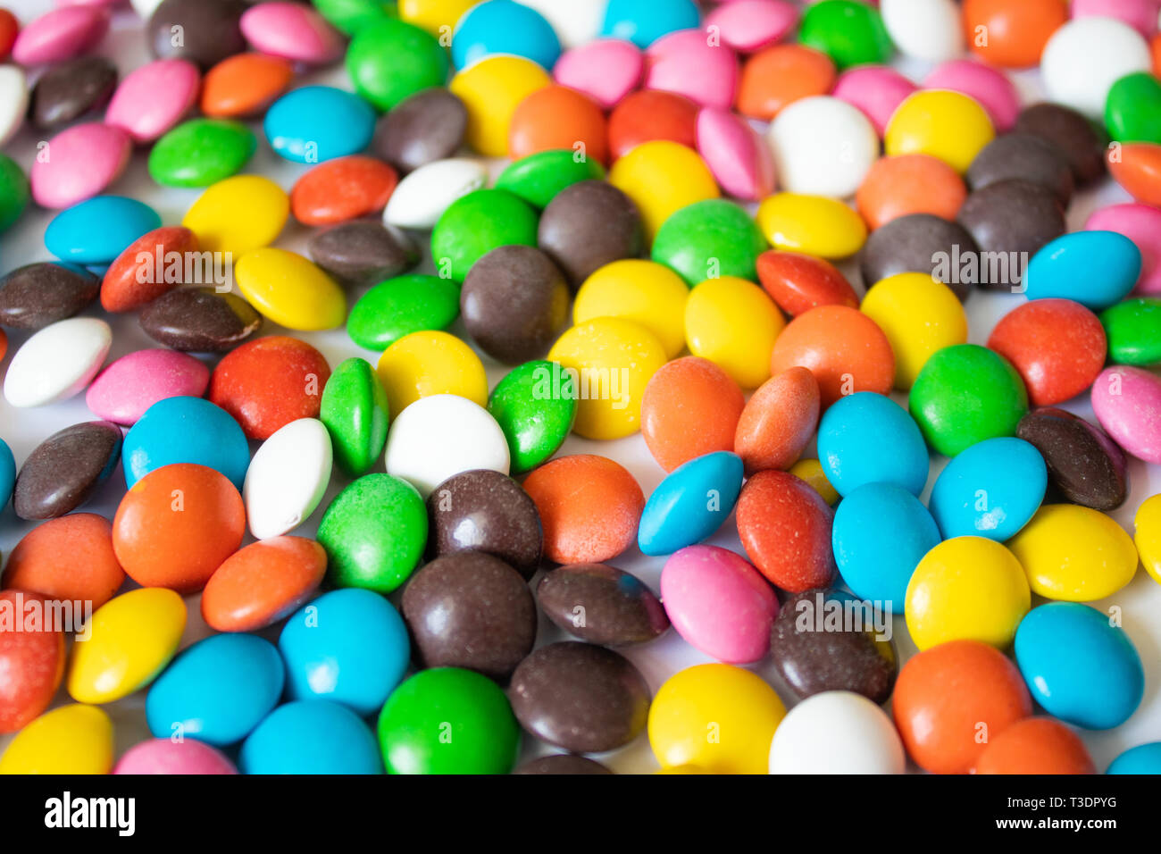 Round, multi-colored, chocolates. Close-up. A pile of multicolored ...