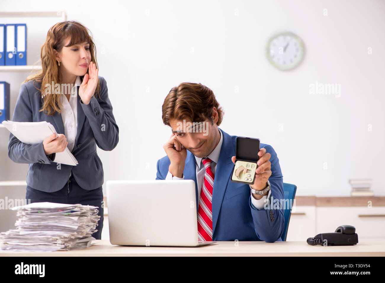 Deaf employee using hearing aid talking to boss Stock Photo - Alamy