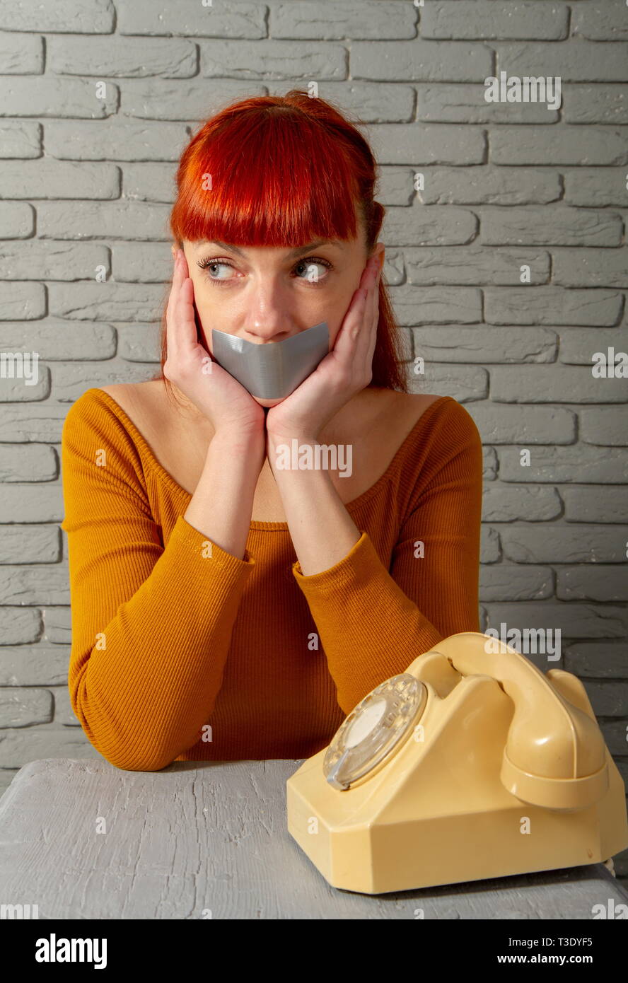 Conceptual picture. Young red-haired girl sitting near an old dial-up ...