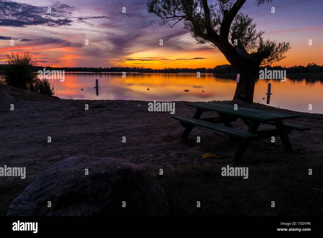 Sunset sky by cottage lake with colorful cloud reflection on lake water ...