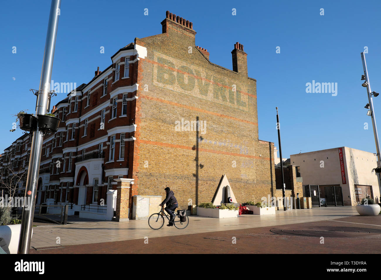 Man on bike cyclist cycling in Windrush Square and the Bovril building ...