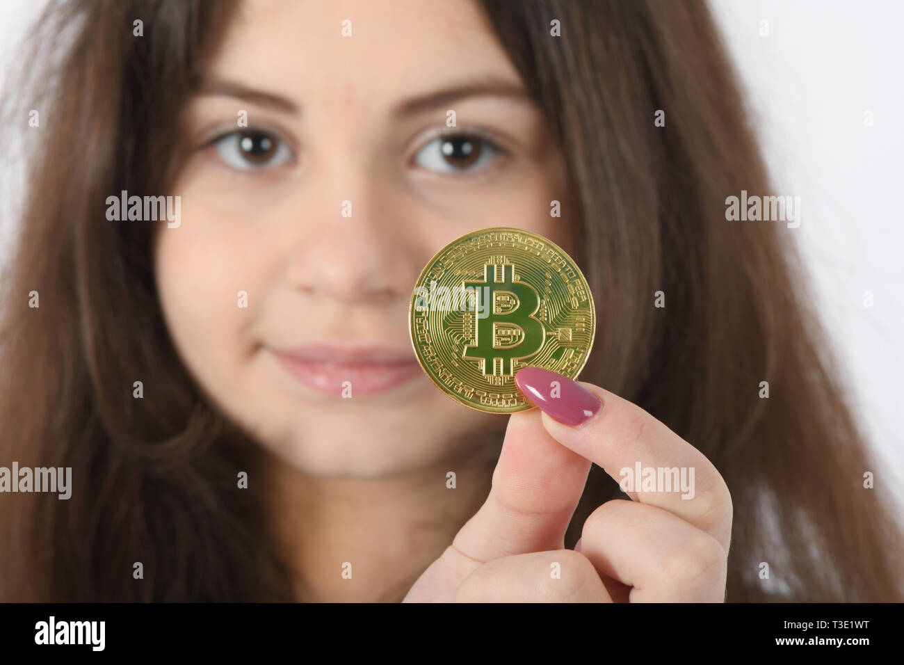 Pretty Girl holding in front of her new golden cryptocurrency bitcoin ...