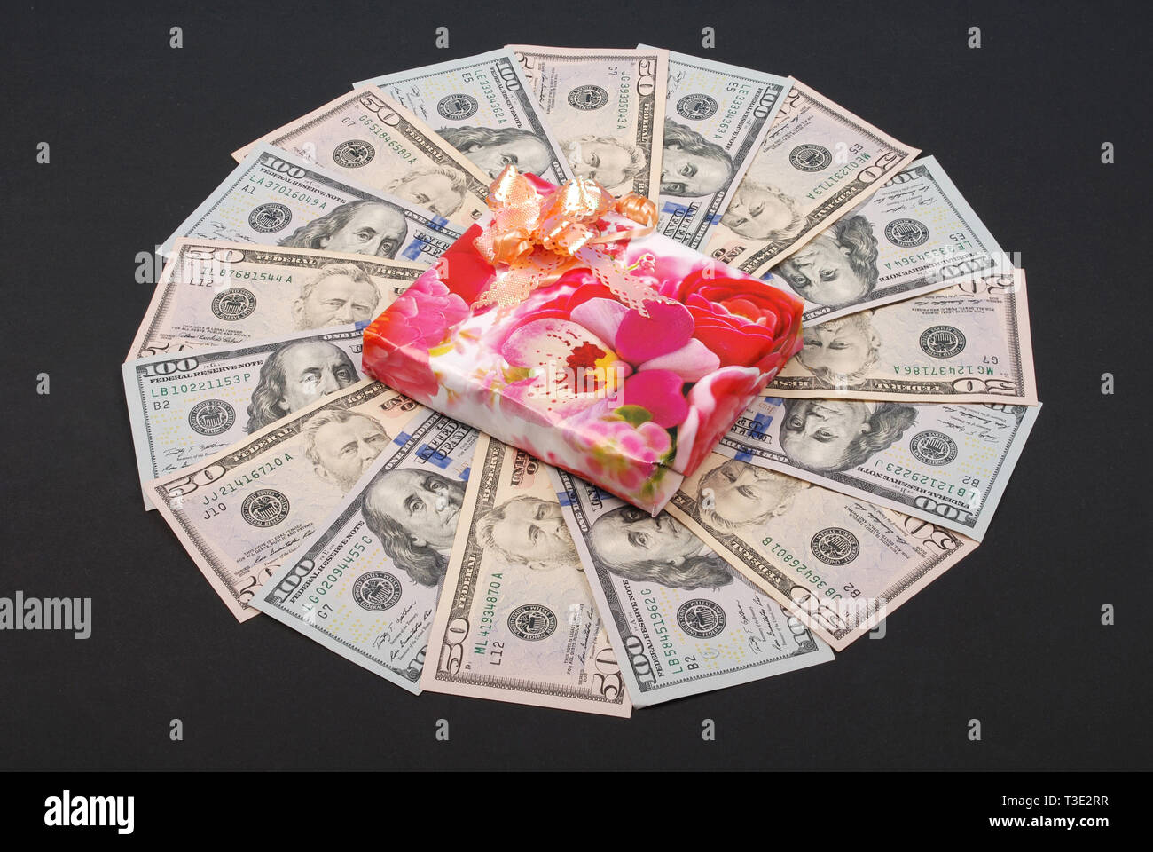 Gift box on money, in the shape of a circle isolated on black ...