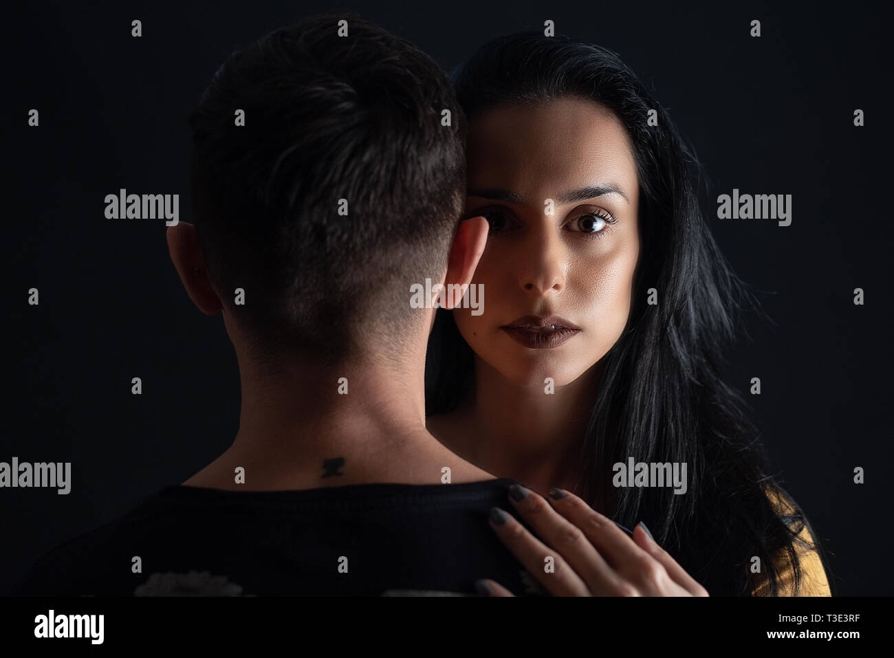 Studio portrait of a couple with mans back to the camera and woman ...