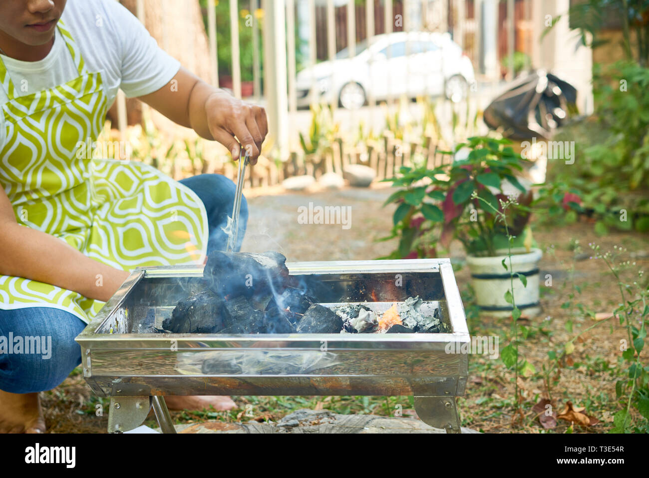 Man lighting fire for barbecue Stock Photo - Alamy