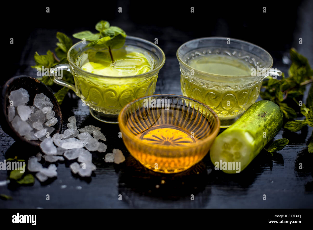 Iced cucumber and mint tea on wooden surface in a transparent cup with ...