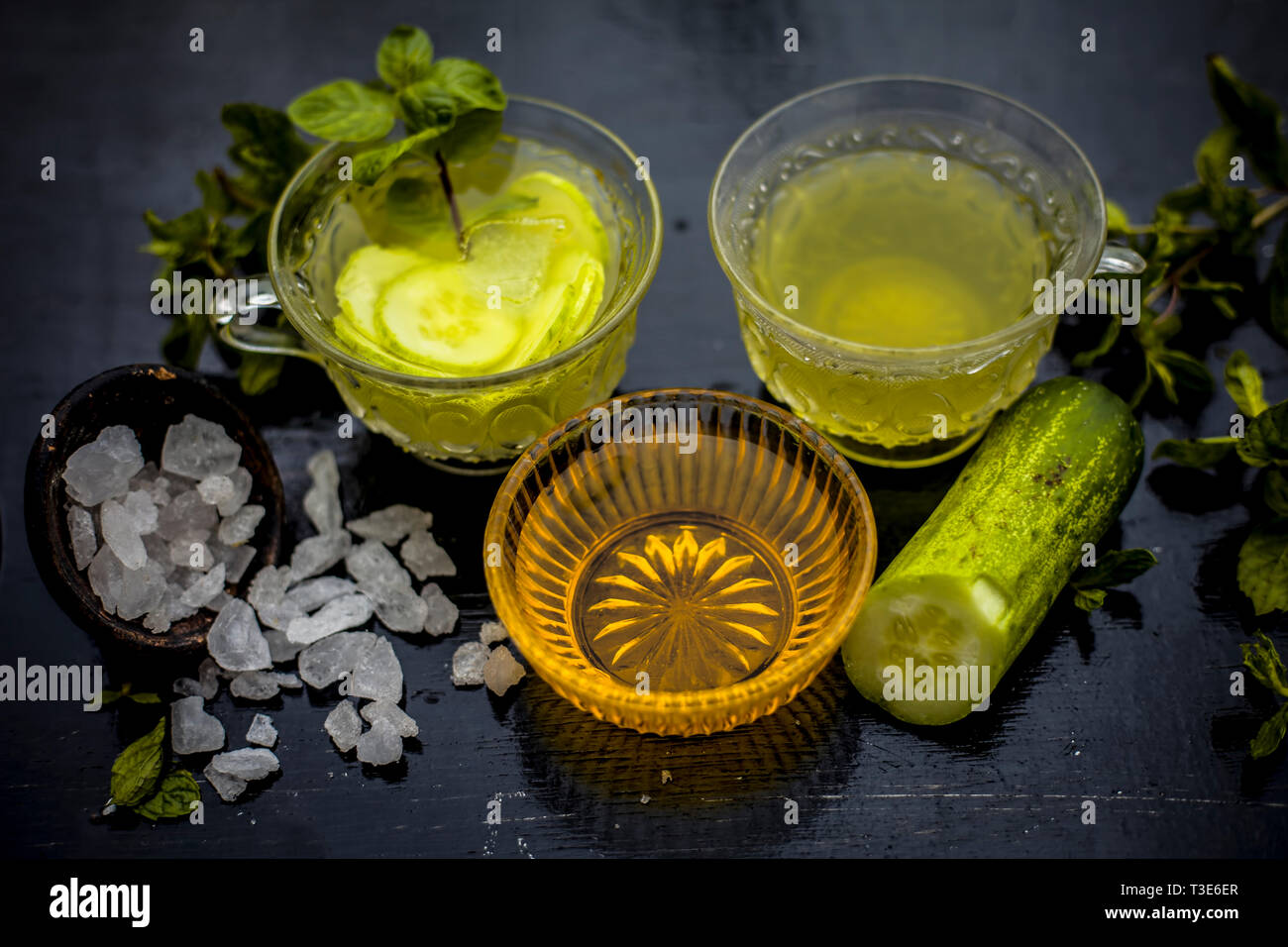 Iced cucumber and mint tea on wooden surface in a transparent cup with ...