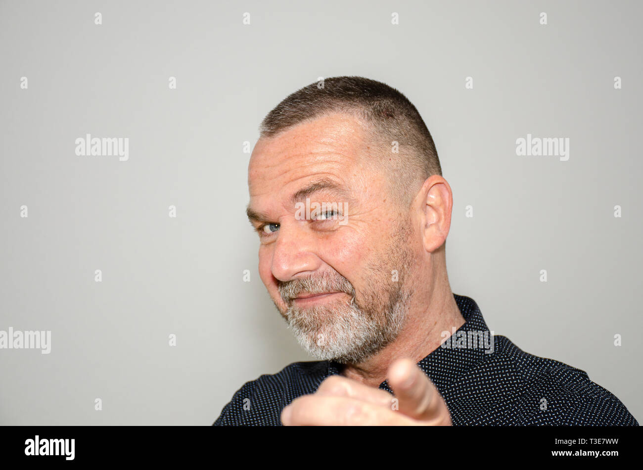 Charismatic middle-aged man pointing a finger at the camera with a ...