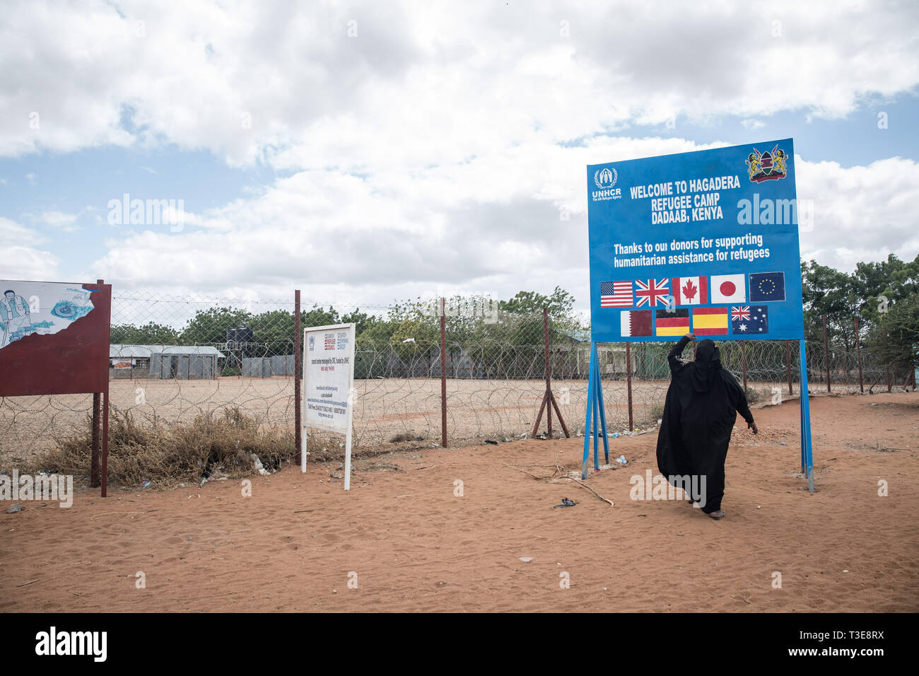 A woman seen standing in front of a UNHCR sign in the refugee camp ...