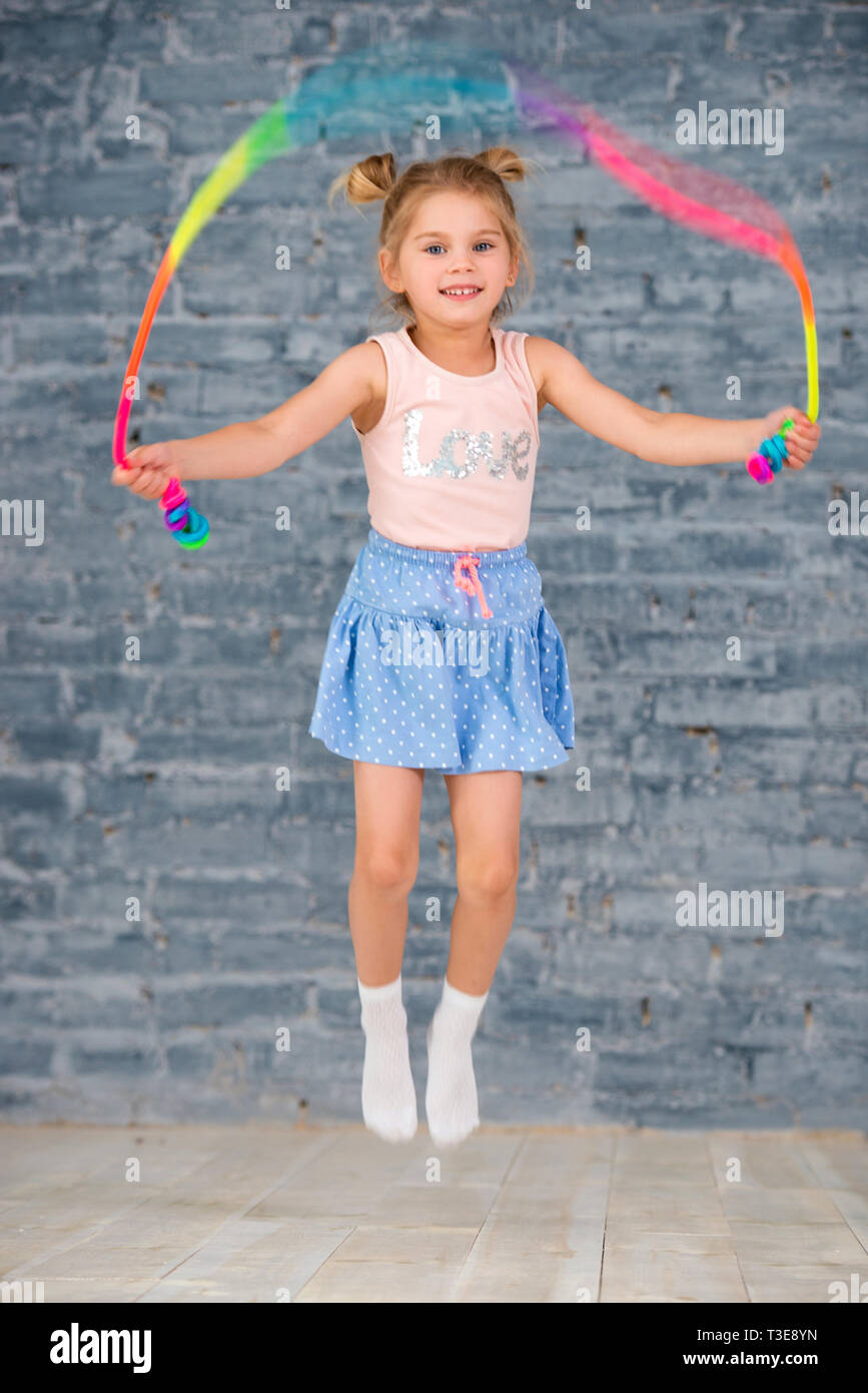 baby little cheerful girl jumping with rope Stock Photo - Alamy