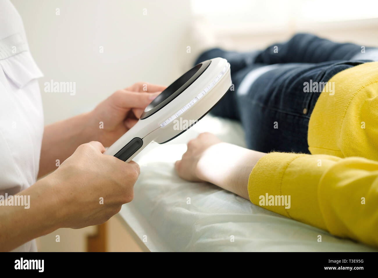 Dermatologist using a professional magnifying glass while doing skin ...