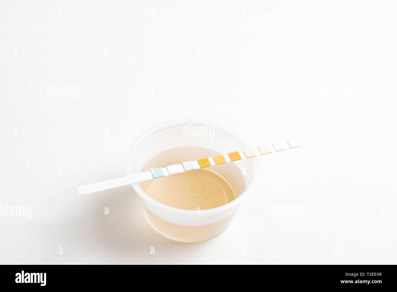 A combination of urine sample on a small round plastic container and a ...