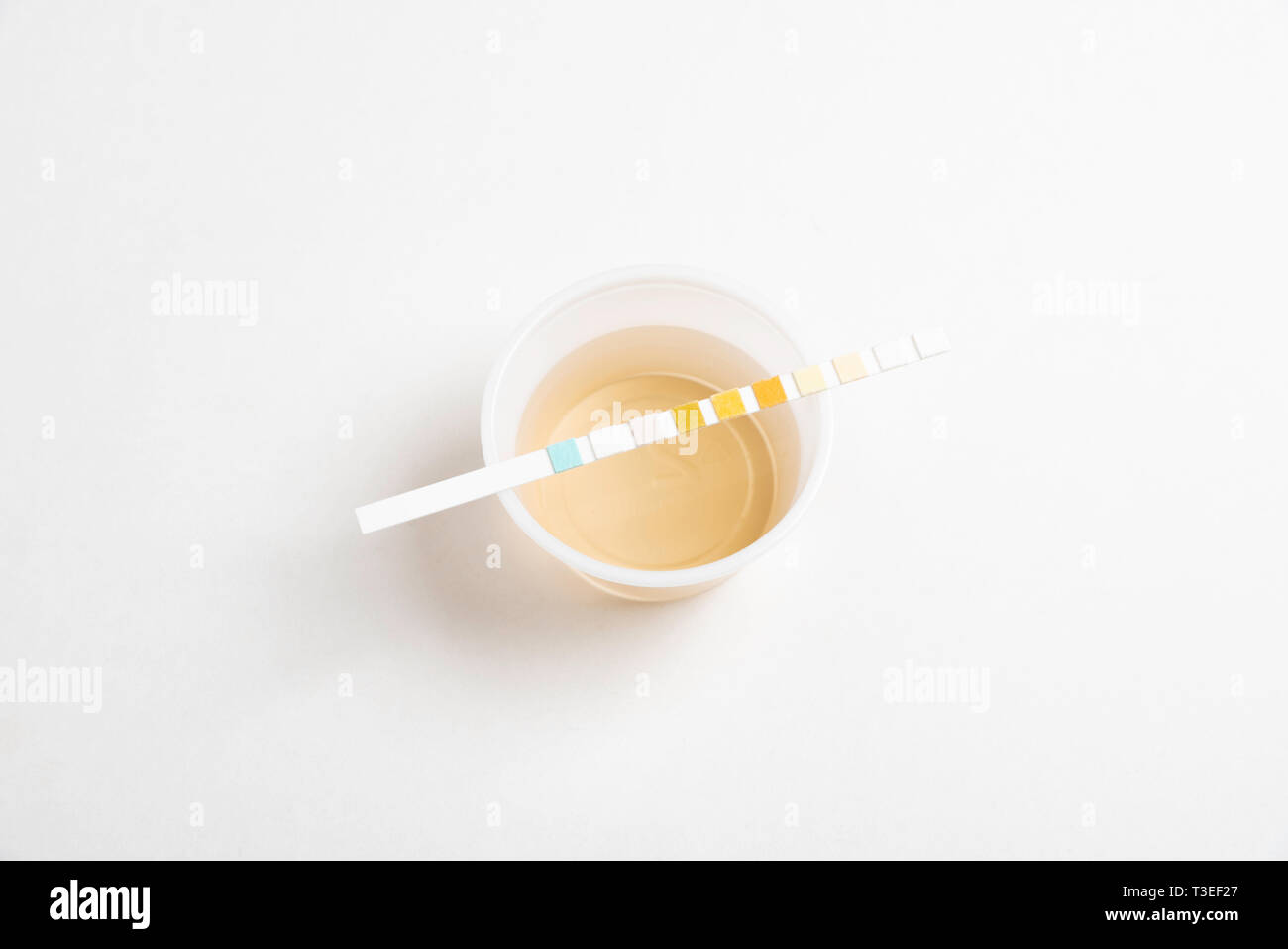 A combination of urine sample on a small round plastic container and a ...